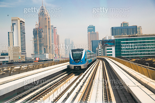 Dubai metro railway track view with City buildings and approaching ...