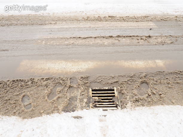 Snow, ice, slush and winter mud at a pedestrian crossing. The air ...
