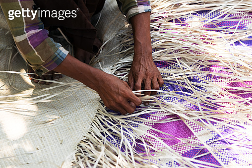 Woman weaving a traditional mat made from screw pines or Pandanus ...