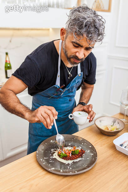 Latin cook preparing octopus at private dinner at home 이미지 (1370869558 ...