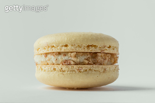 Yellow macaroon with vanilla ganache filling decorated with crushed ...
