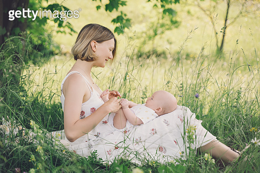 Beautiful mother and baby on nature. Young woman with her baby in ...