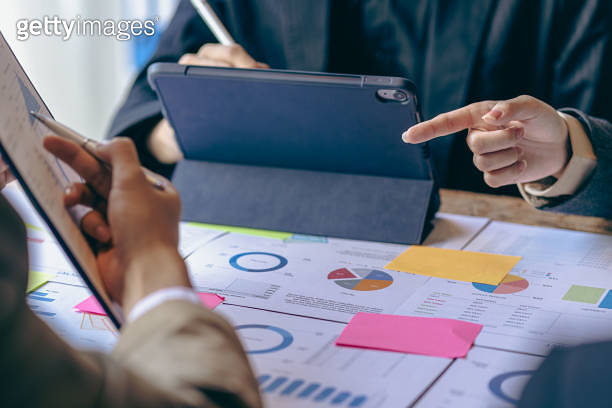 Business consultants analyze financial figures showing the progress of ...