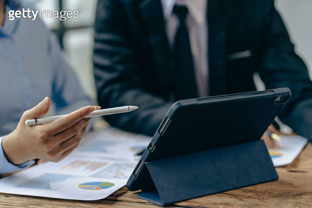 Business consultants analyze financial figures showing the progress of ...