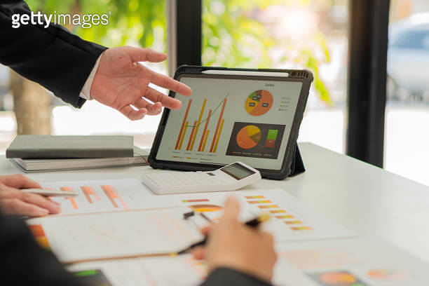 Business consultants analyze financial figures showing the progress of ...