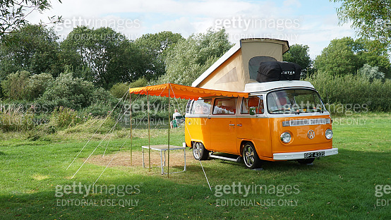 Classic Orange Volkswagen Camper Van parked on Camp Site by river with ...