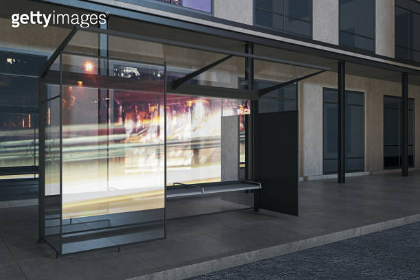 Contemporary glass bus stop with city reflections and daylight ...