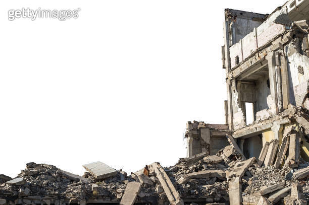 A large ruined building with a pile of construction debris and concrete ...