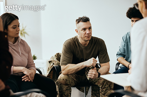 Military officer listening to therapist while having group therapy ...