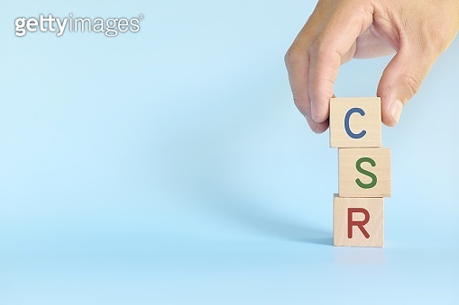 Hand stacking CSR or Corporate Social Responsibility in wooden blocks ...
