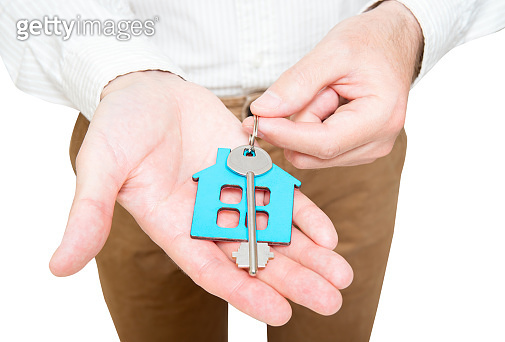 Man holding a house shaped keychain with a key 이미지 (1401942506) - 게티이미지뱅크