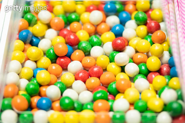 Closeup of multi color candy balls in transparent box in candy shop ...