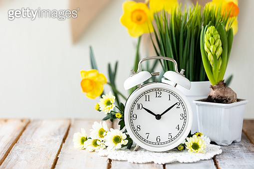 Spring change, Daylight Saving Time concept. White alarm clock and ...