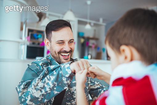 Playful military man having fun with his small son at home 이미지 ...