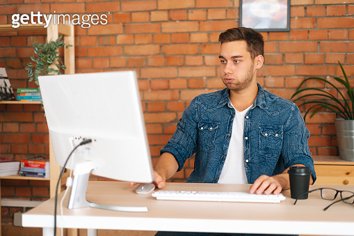 Front view of overworked bored young freelance programmer working on ...