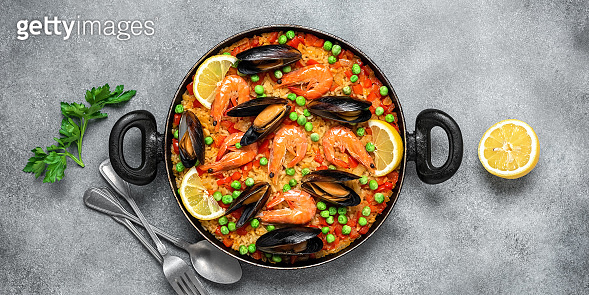 Traditional Spanish paella with seafood in a frying pan. Gray concrete ...