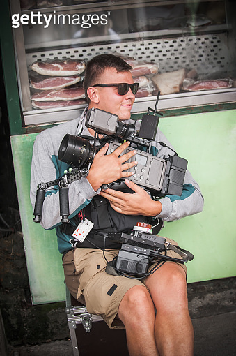 Behind the scenes. Funny cameraman with camera takes a break 이미지 ...