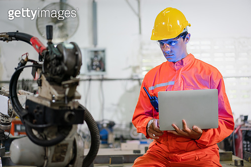 Male automation engineer wear an orange uniform with helmet safety ...