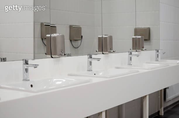 faucet with a sink in a public toilet. Modern public toilet interior ...