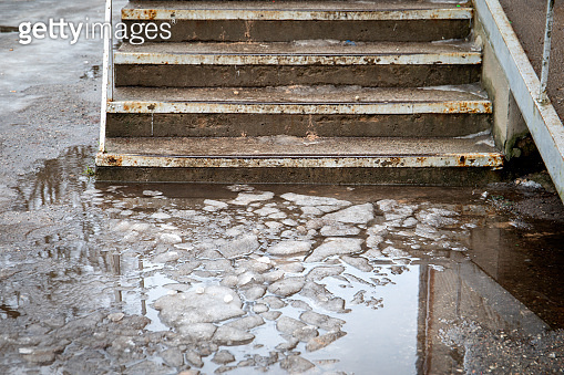 Dangerous and unsafe stairs. Melted snow, water and slippery. Concrete ...