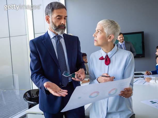 Portrait Of Happy Senior Business People Discussing Together In Office