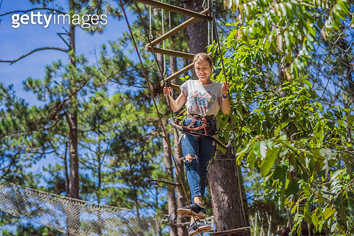 Young attractive woman in adventure rope park in safety equipment 이미지 ...