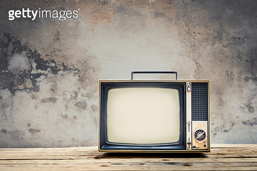 Retro old television on wood table with old concrete wall background ...
