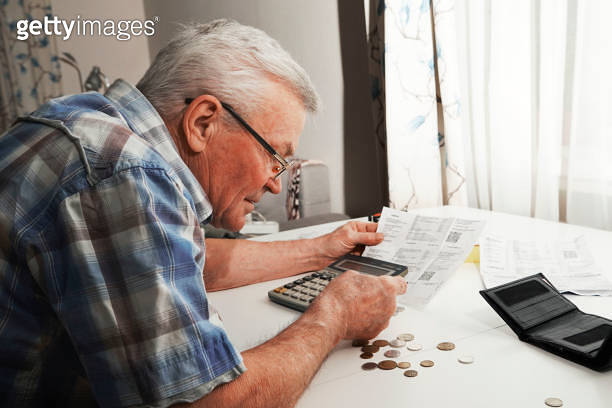 Senior man sitting at the table and calculating finances. Old man ...