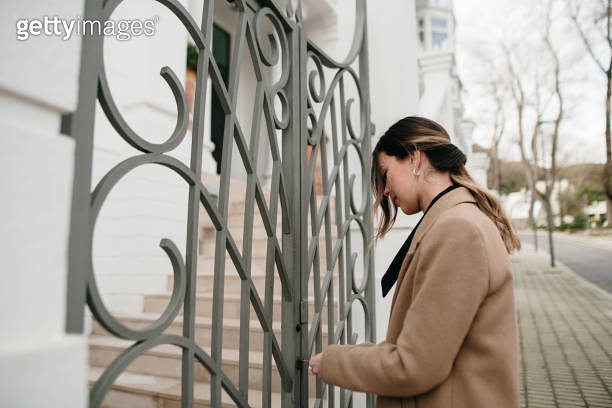 Young woman opening a apartment gate 이미지 (1369353656) - 게티이미지뱅크