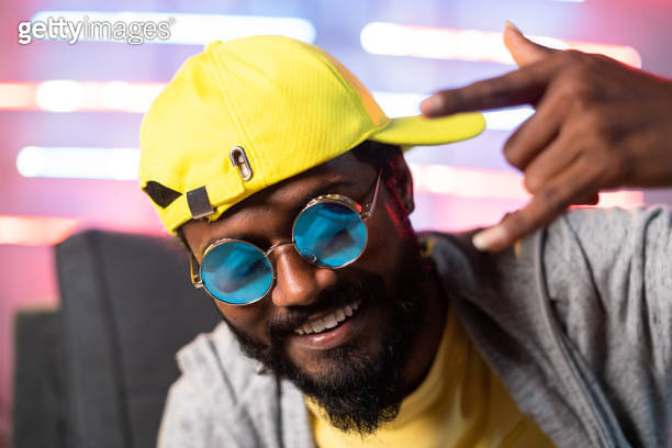 close up shot of hip hop rapper singing by looking at camera on neaon ...