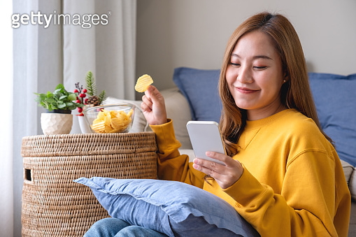 Portrait image of a beautiful young woman using mobile phone while ...