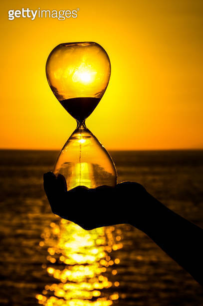 Time is running fast. Hourglass in the hands symbolize the transience ...