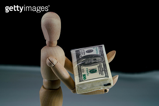 wooden dummy and dollar coins bill, business concept, puppet made of ...