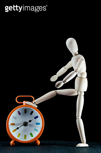 wooden dummy and analogic clock, time concept, puppet made of wood, art ...