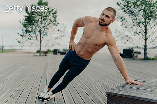 Young handsome shirtless ordinary bearded man stands in diagonal body ...