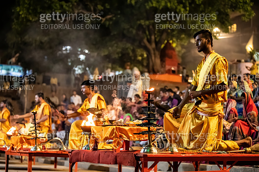 Hindu priests perform an Arti worship ceremony at the ghats in Varanasi ...
