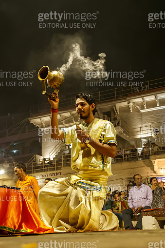 Hindu priests perform an Arti worship ceremony at the ghats in Varanasi ...