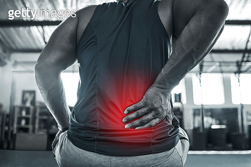Back pain in the gym is never good. Athlete touching his back in pain ...