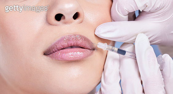 Closeup of a gorgeous mixed race woman getting botox filler in her face ...