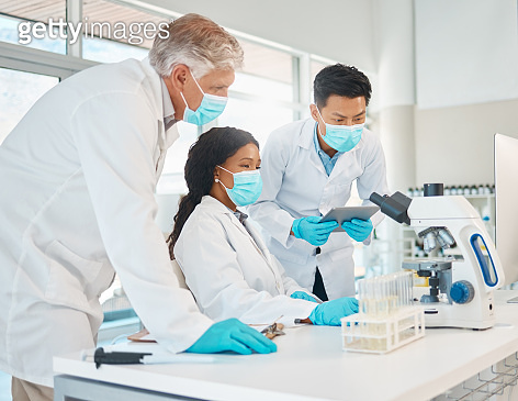 Shot of a group of scientists working together on a computer in a lab ...