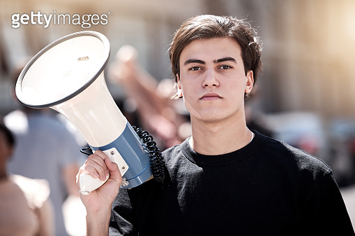 Shot of a young man holding a megaphone during a protest rally 이미지 ...