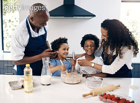 Happy african american family baking in their kitchen together ...