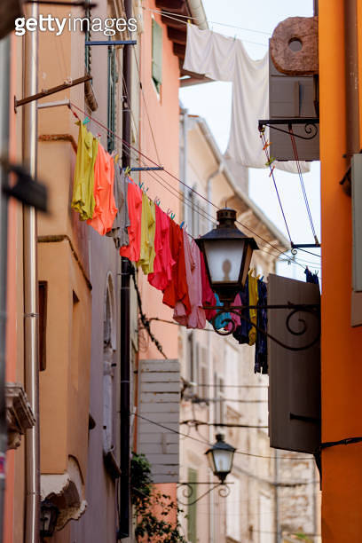 Narrow space between houses in Rovinj with clothes line overhanging ...
