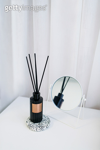black aroma diffuser with round mirror on a white table. Relax spa ...