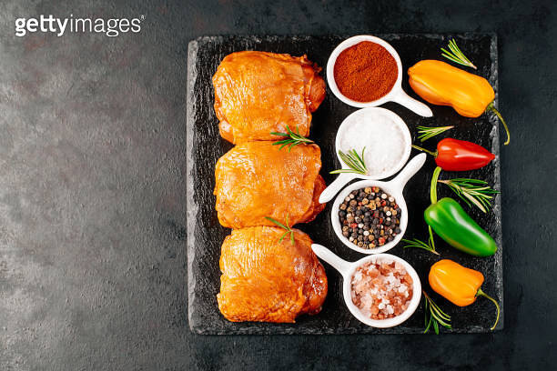Fried chicken thighs with various spices, in red sauce.Fast food ...