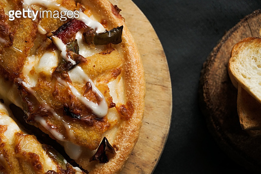 close up view of the tempting pizza with a cheese sauce beside. a baked ...