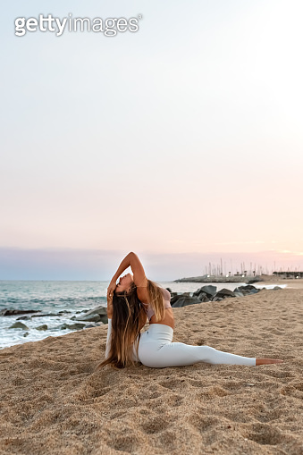 Young flexible caucasian woman practicing yoga doing splits on the ...