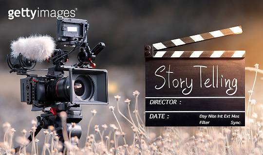 Storytelling.hand writing on film slate and a camera filming a movie in ...