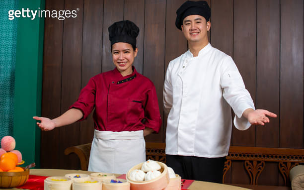 Two young adult traditional professional couple Chinese chefs wearing ...