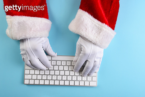 High angle closeup of Santa Claus hands using his computer keyboard ...